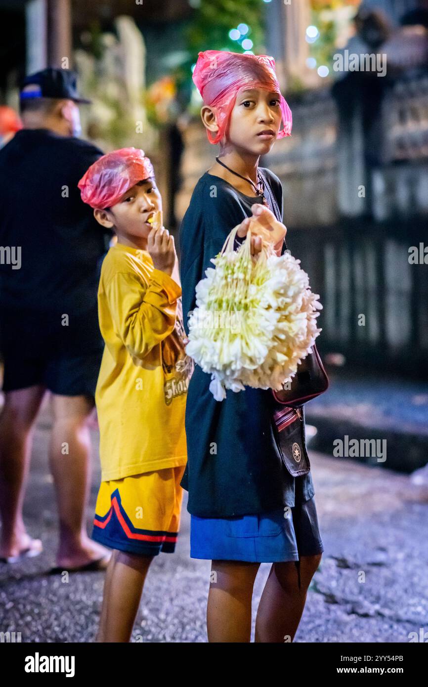 Young filipino boys sell flower garlands to worshippers outside the ...
