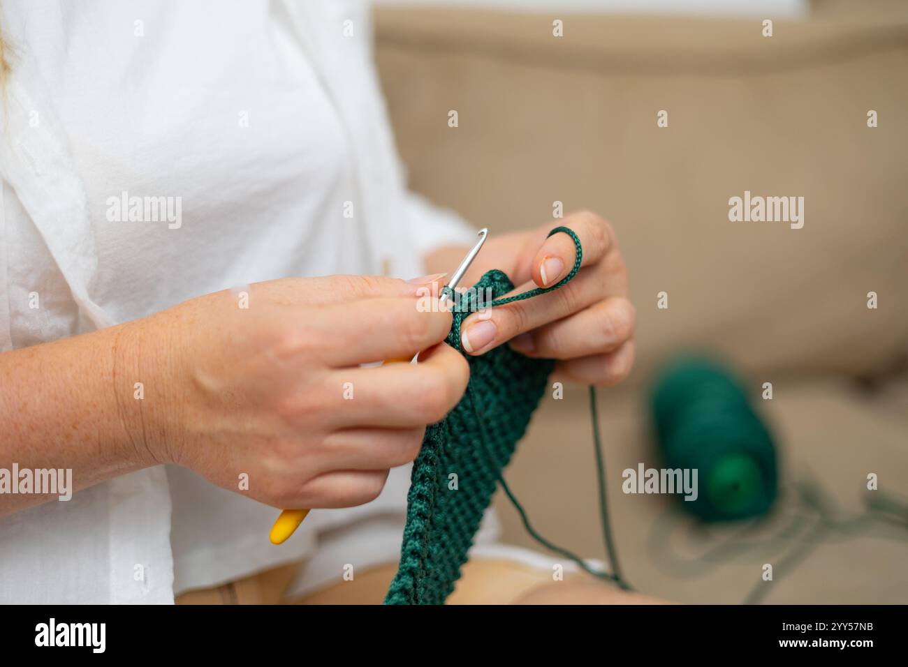 A close-up of crochet accessories, including hooks and yarn on a soft ...