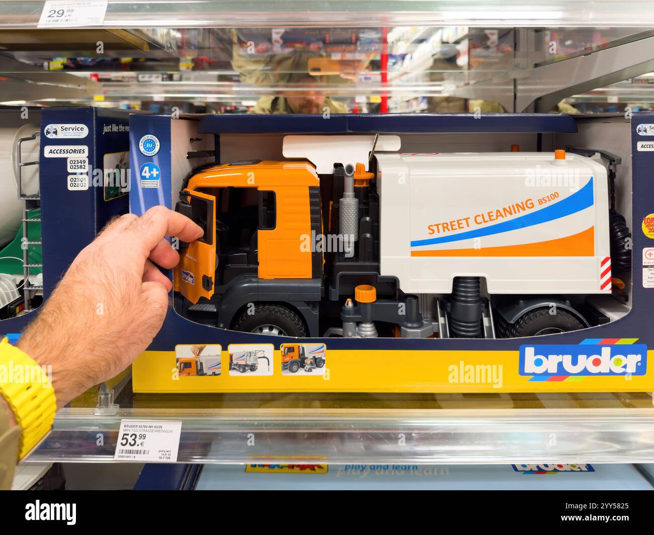 Berlin, Germany - Nov 22, 2024: A Bruder street cleaning truck toy in orange and white on ...