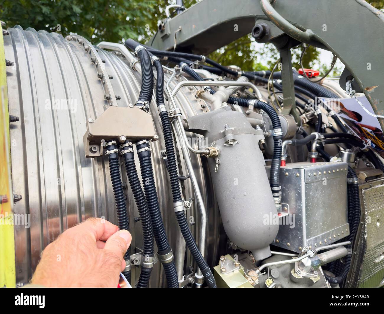 Close-up view of a military jet engine under repair with visible cables ...