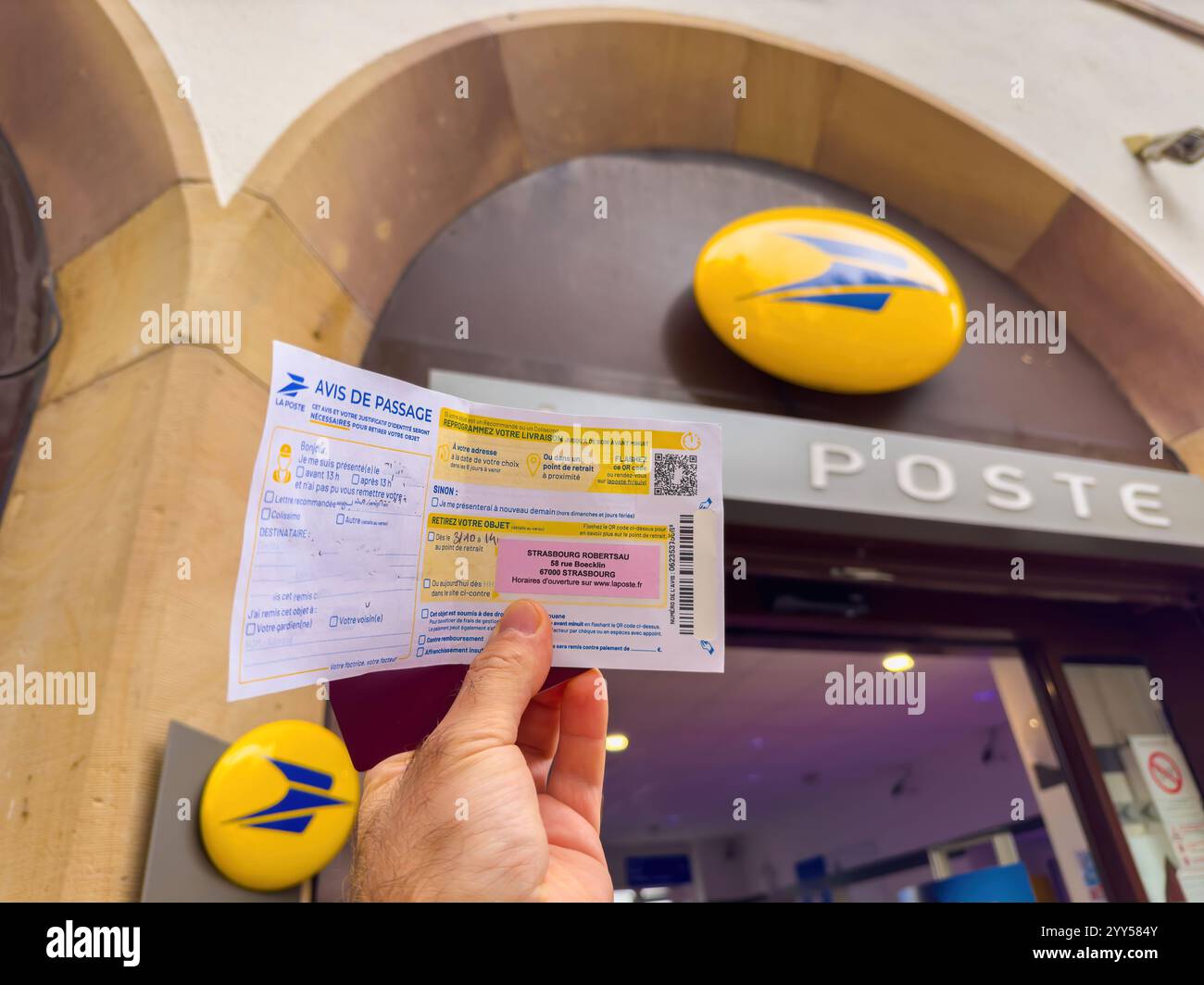 Paris, France - Oct 4, 2024: Hand holding an Avis de Passage notice in ...