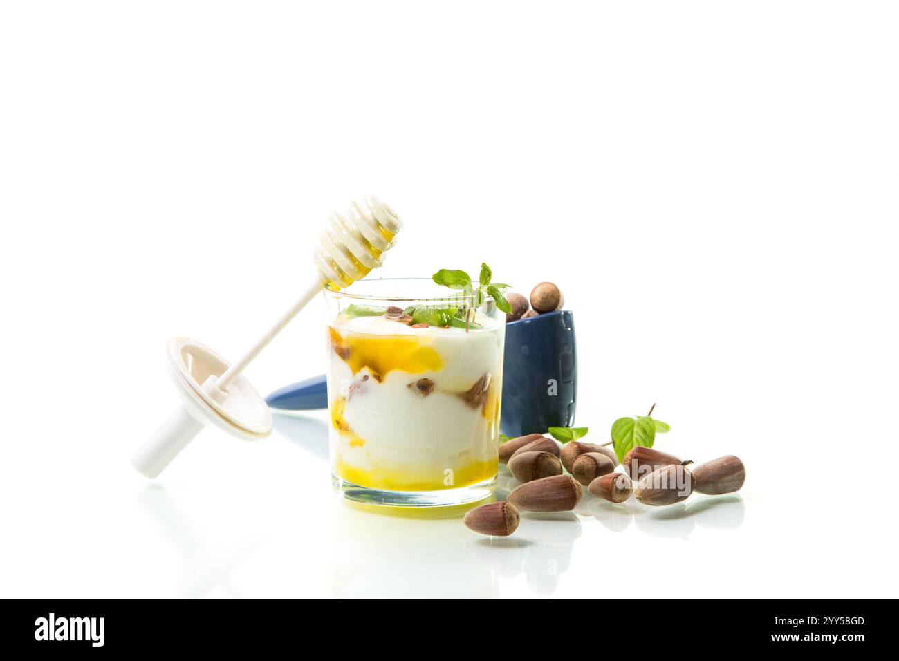 homemade yogurt with kiwi, honey and nuts in a glass, isolated on white ...