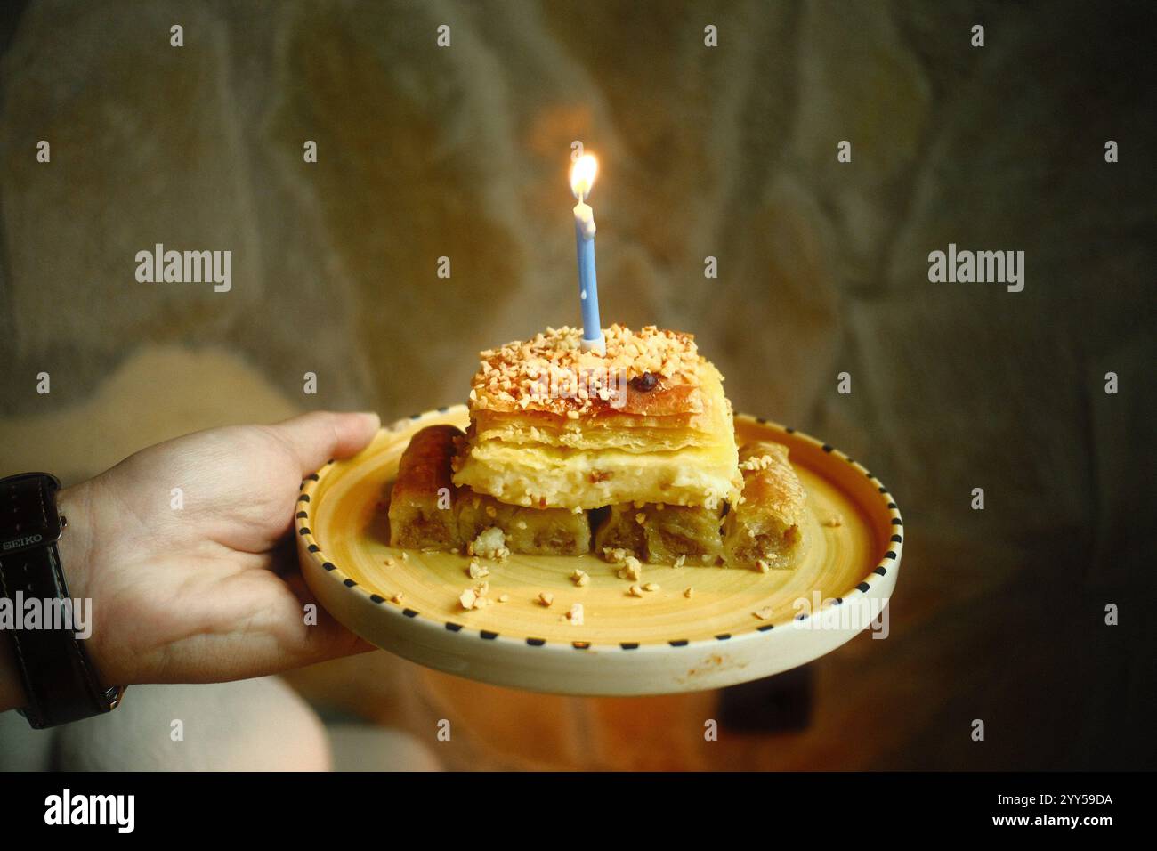 A simple birthday cake made from a stack of baklava, a traditional ...