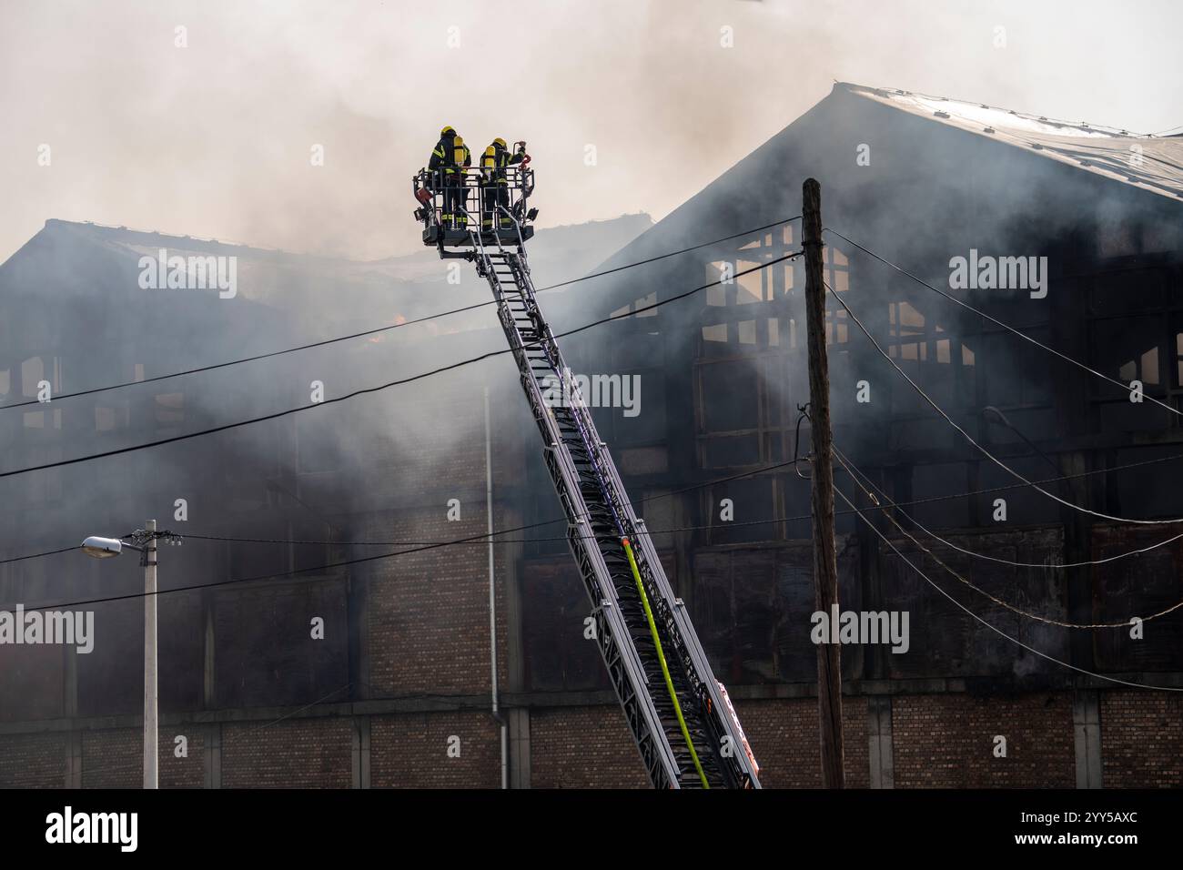 Dramatic scene of Firefighters rising on a mechanical sliding ladder ...