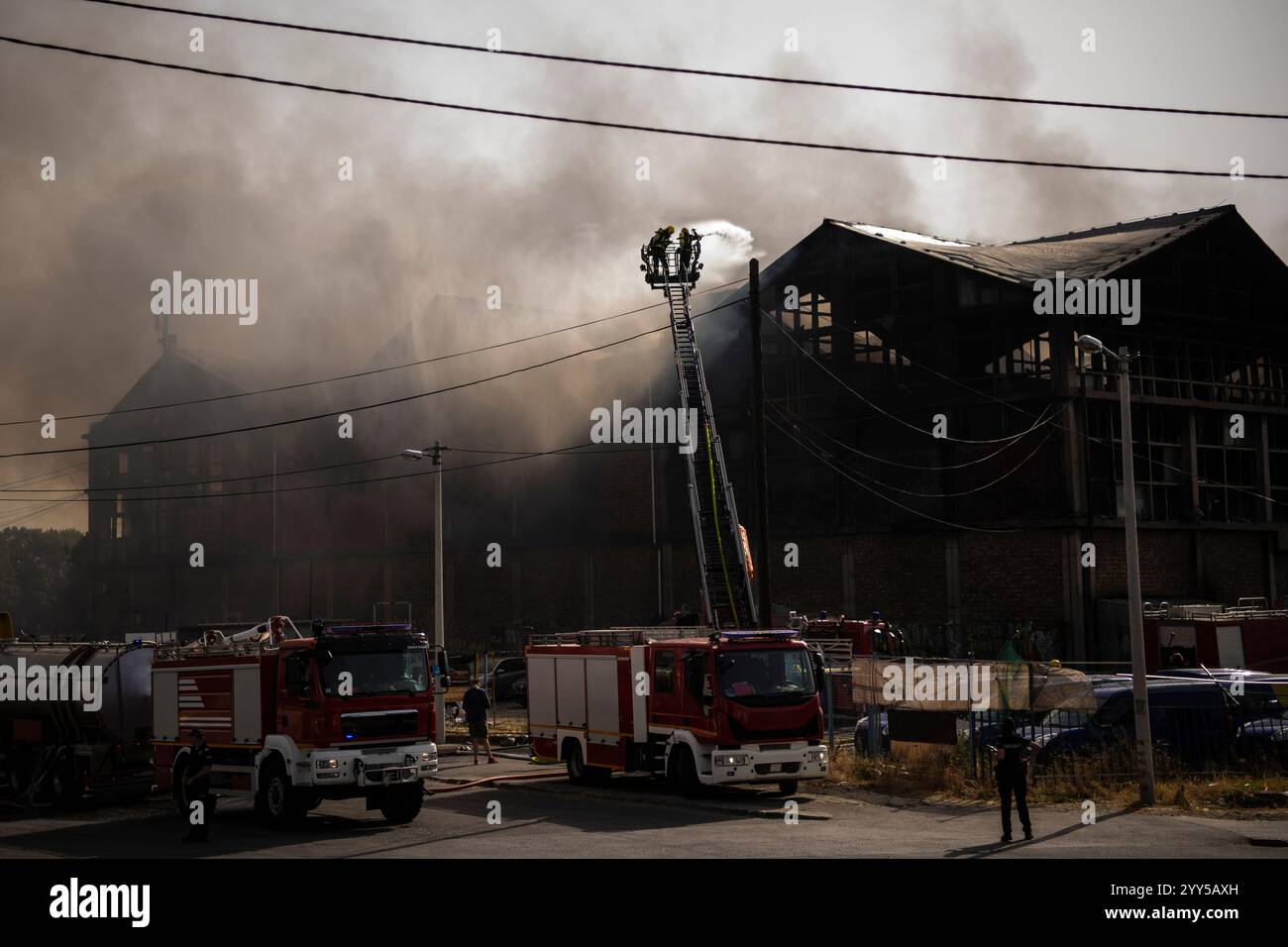 Dramatic scene of Firefighters rising on a mechanical sliding ladder ...