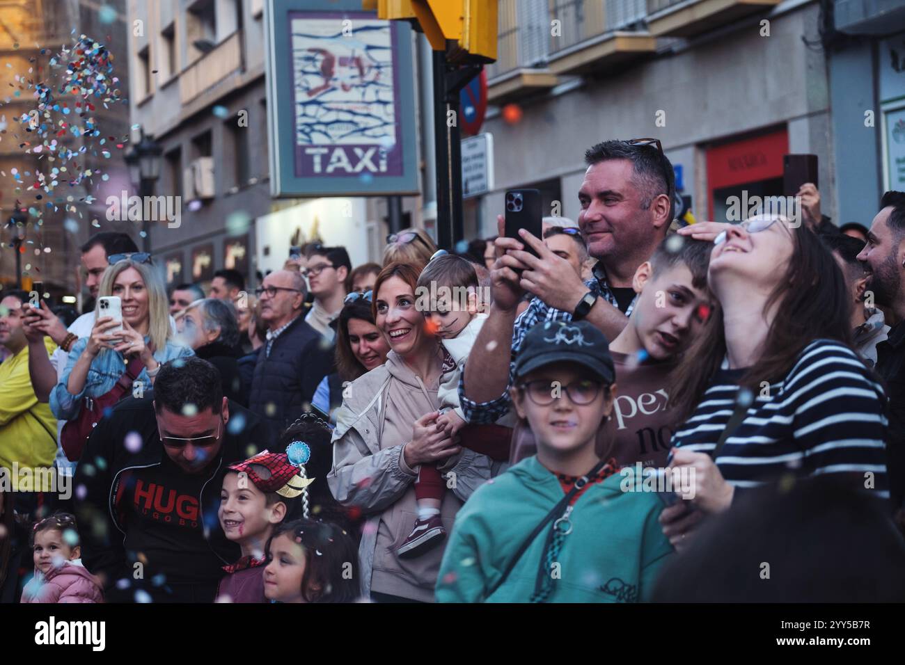 Diverse crowd enjoying a festivity in a city street, capturing moments ...