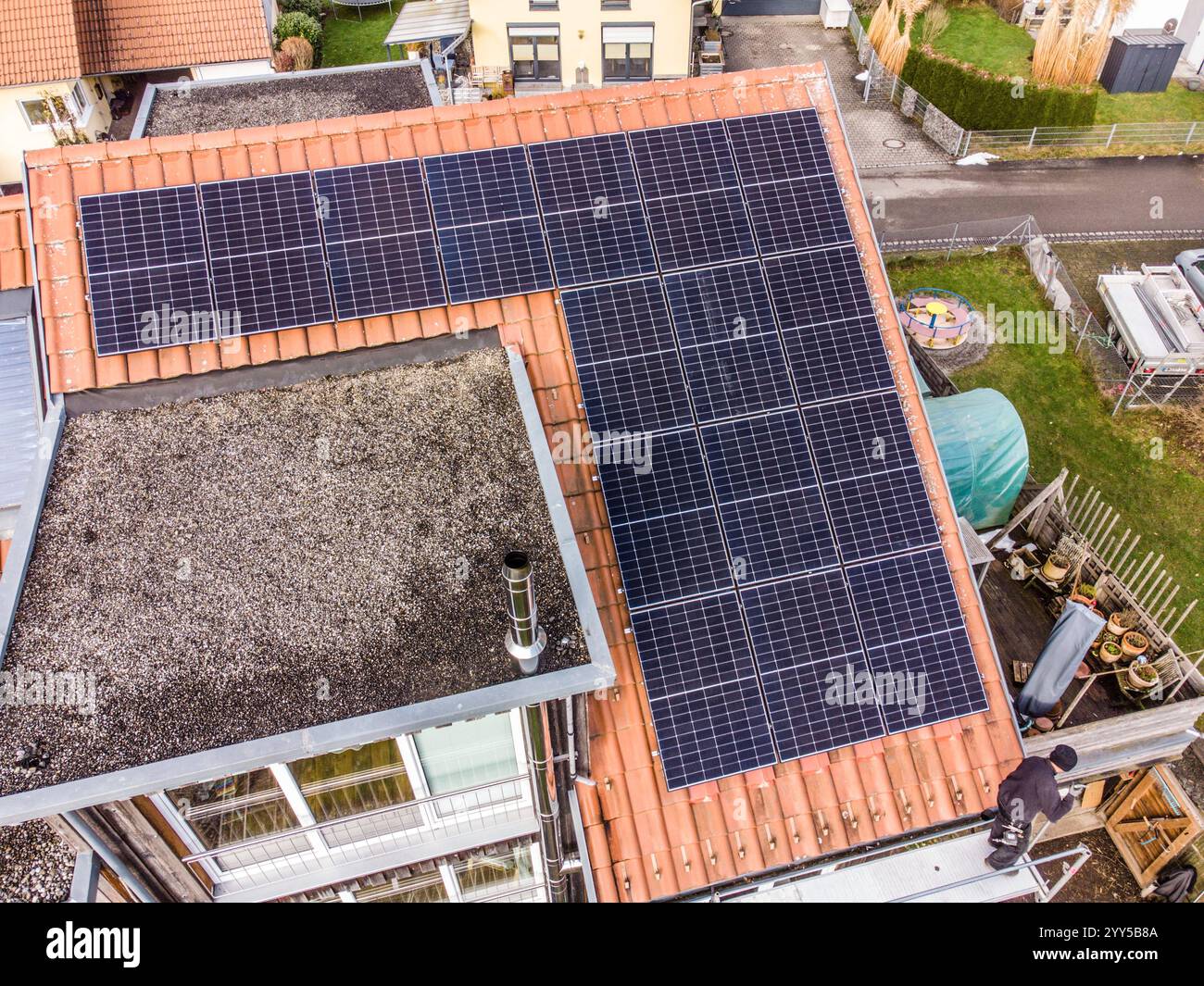Auf einem Passivhaus aus Holz montiert ein Monteur Solarpanele auf dem Dach. Leutkirch, Baden ...