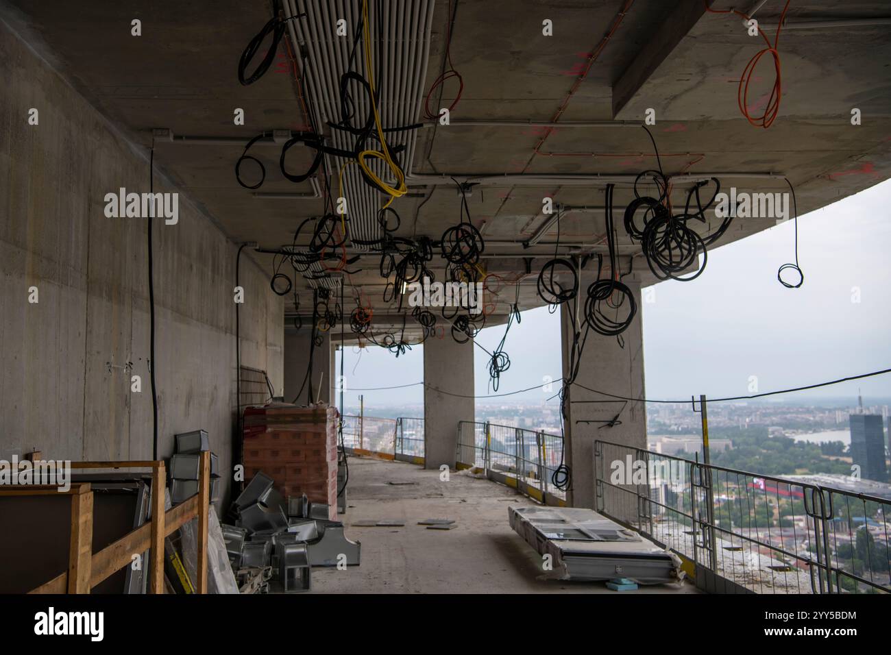 interior of skyscraper floor under construction. Cables, pipes and ...