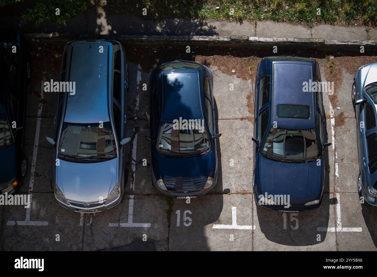 Cars parked in front of residential building. View from above. Covered parking spots. Multi ...