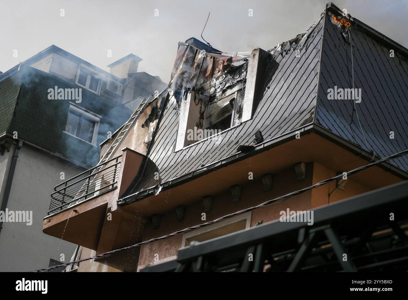 Rooftop of residential housebuilding on fire and burning down. Burning ...