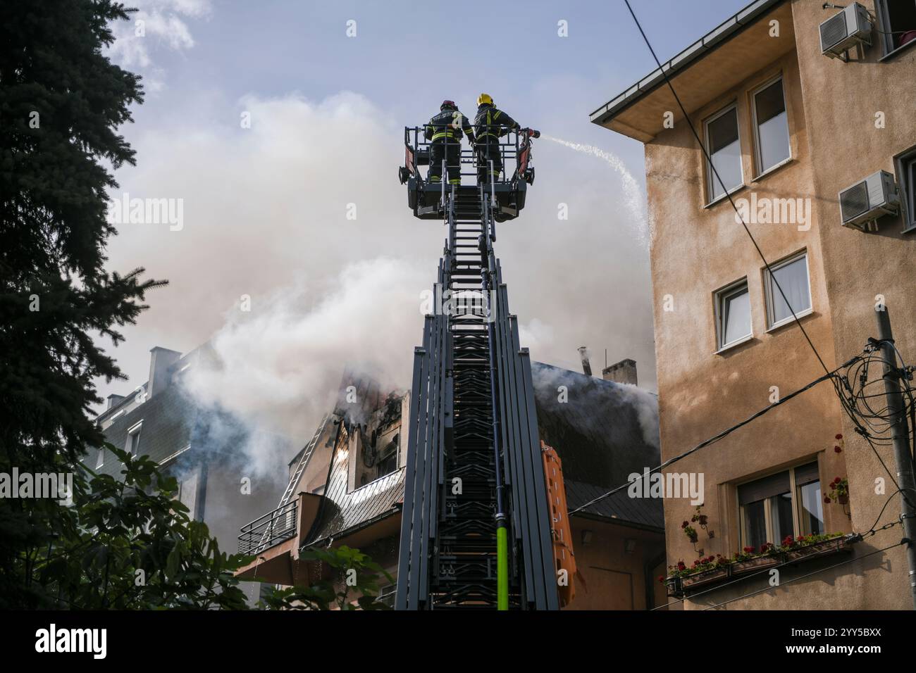 Dramatic scene of Firefighters rising on a mechanical sliding ladder ...