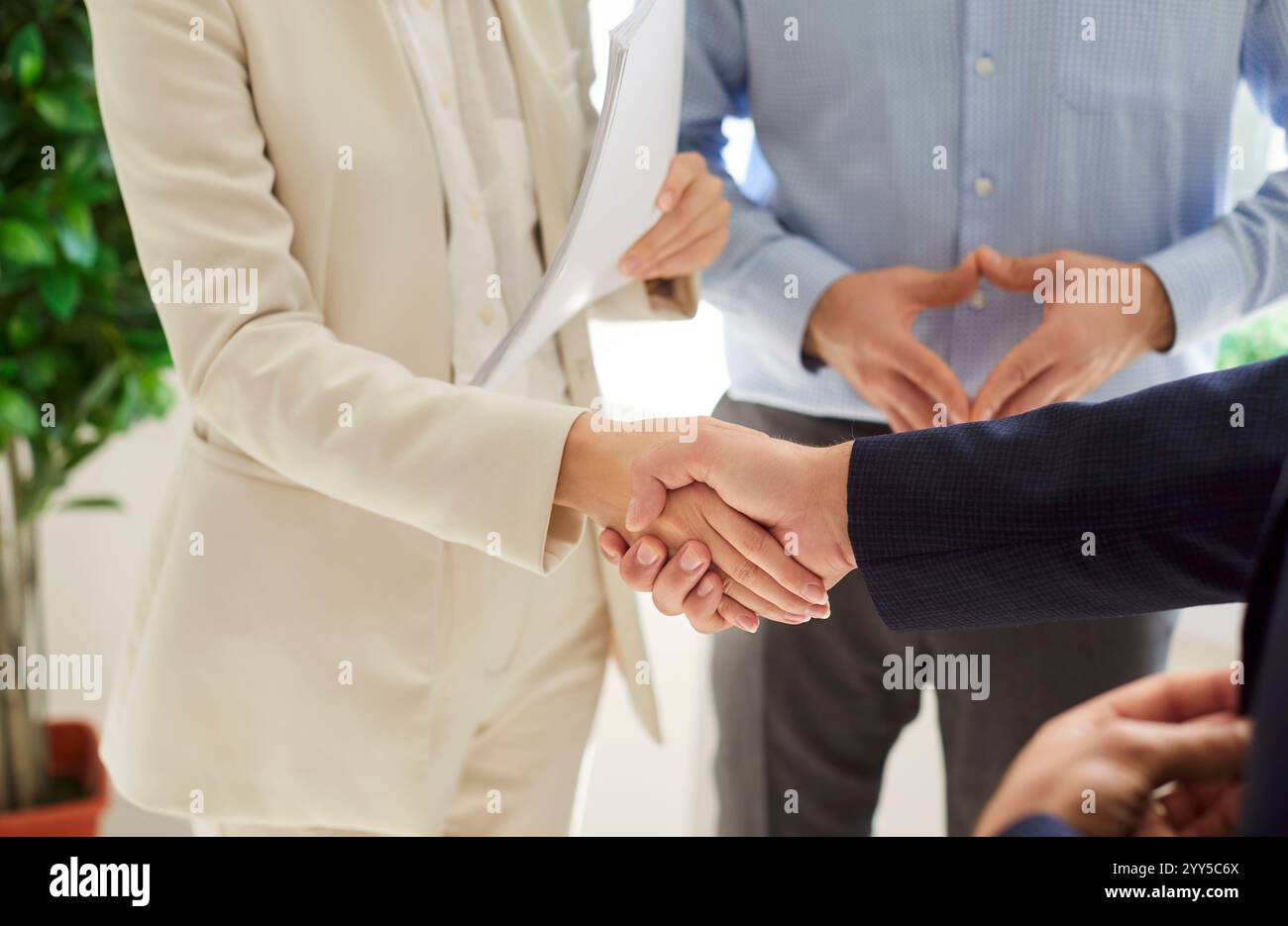 Close up of handshake between woman in beige suit and man, making ...