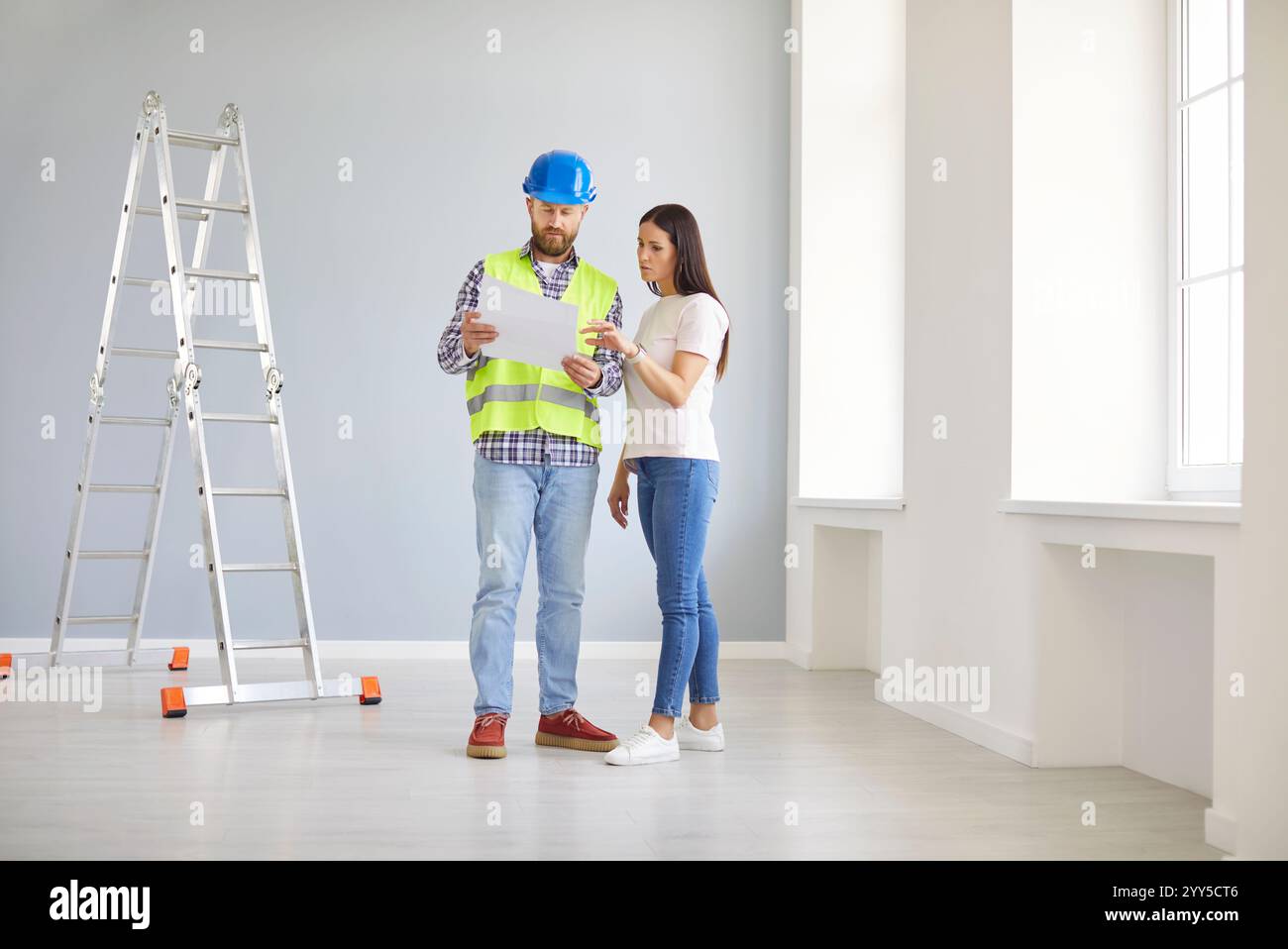 Skilled professional repairman explaining project plan, architect ...