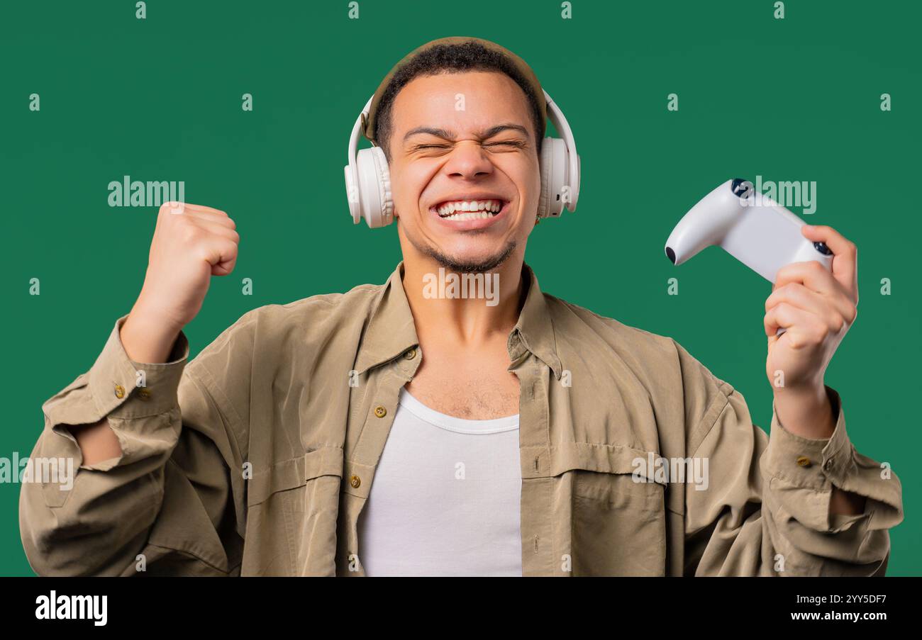 Excited gamer man playing, winning online video game on console with ...