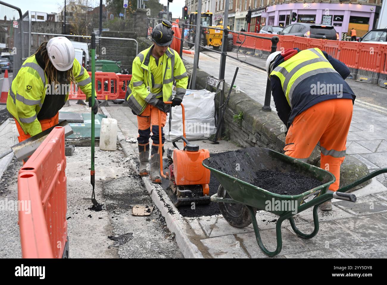 Construction workman hand laying tarmac, using vibrating plate ...