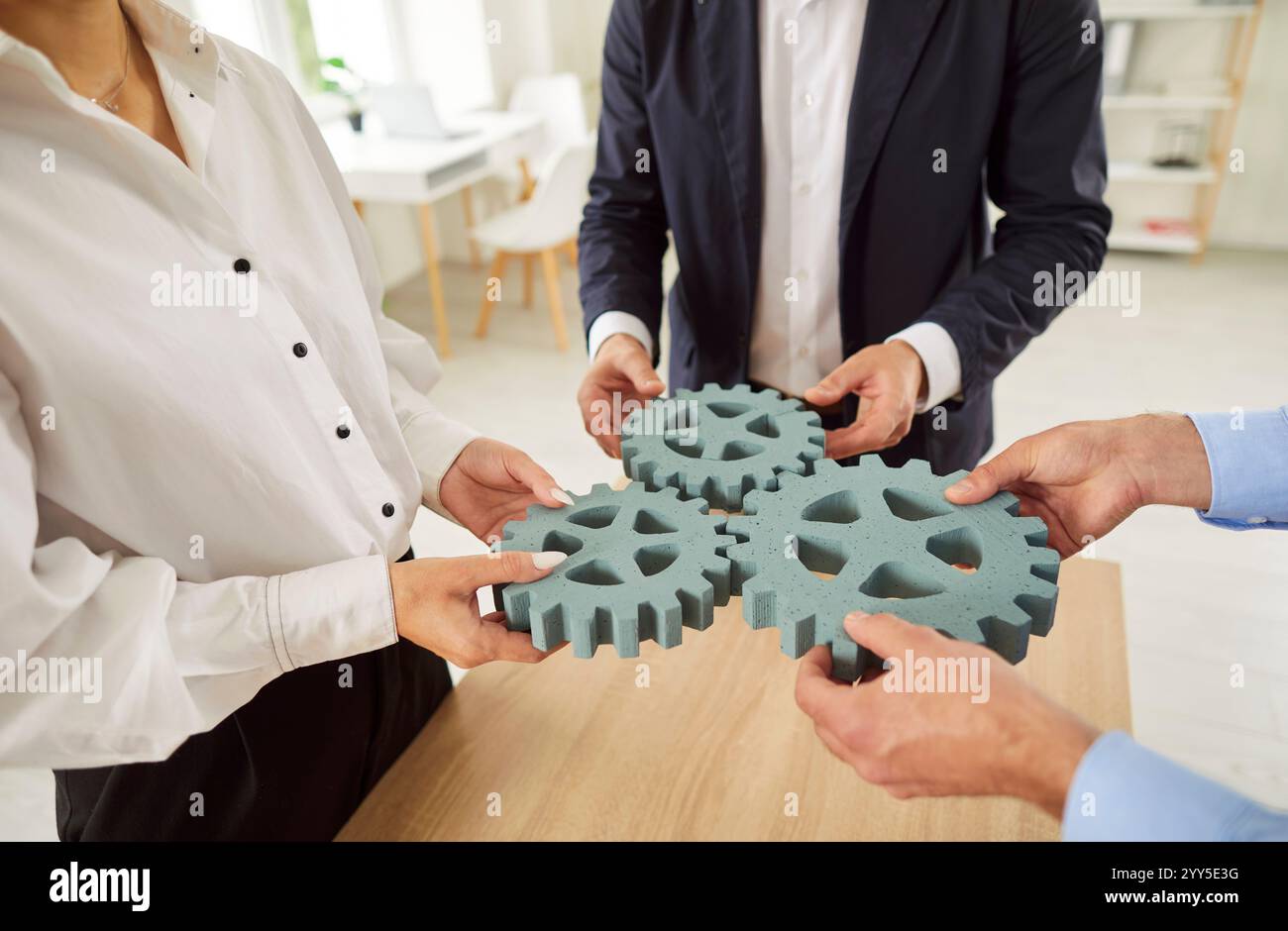 Business people hands connecting big gears together standing at desk in ...