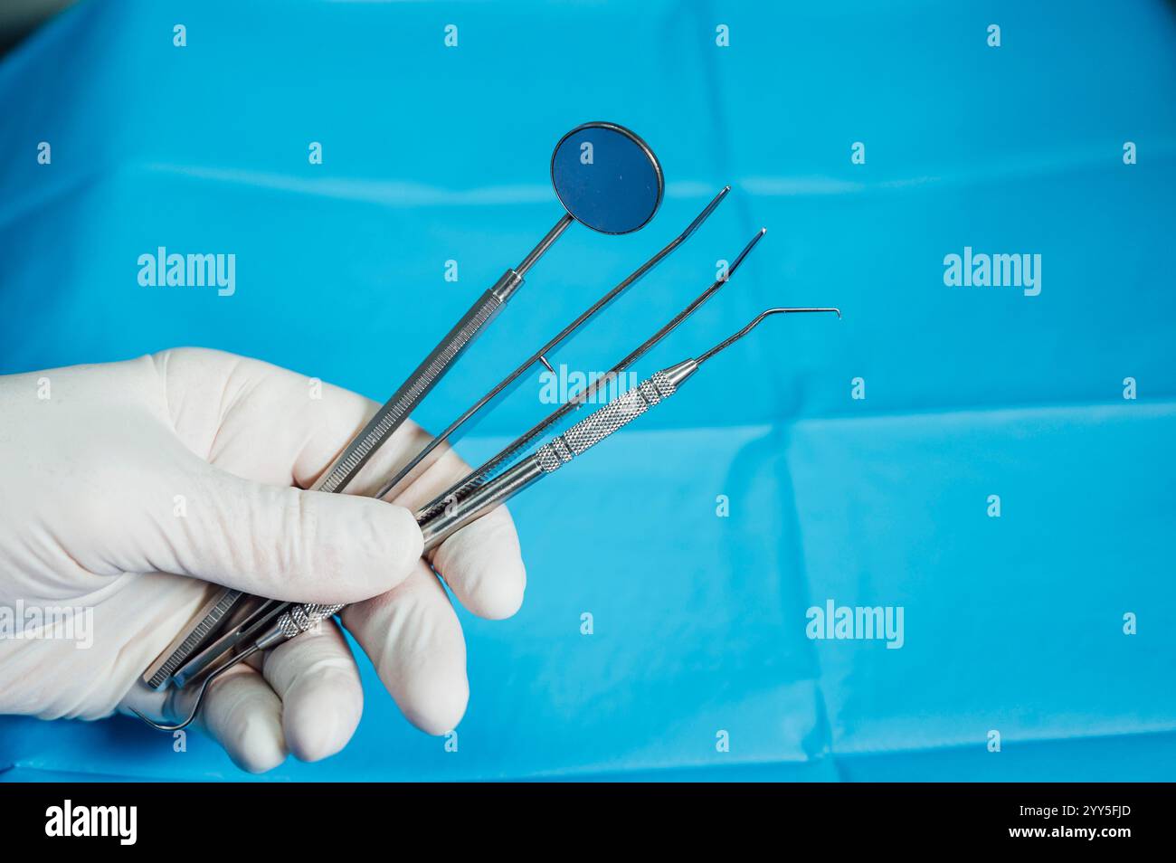Detail of hand holding dental tools in dental clinic. Dental clinic ...