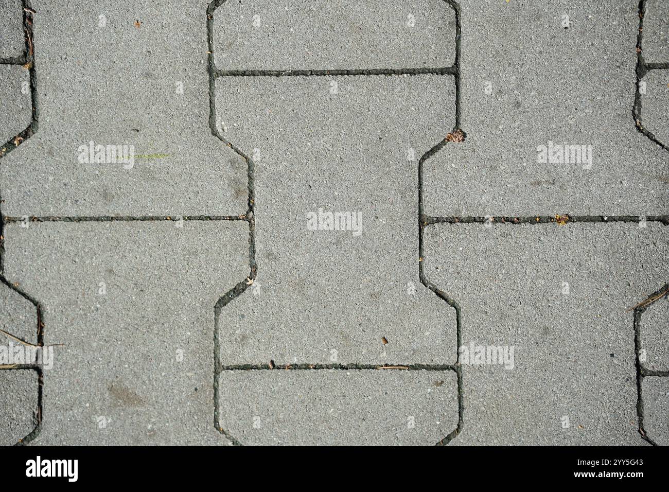 A close-up view of concrete pavement surface, showcasing interlocking pavers arranged in a ...