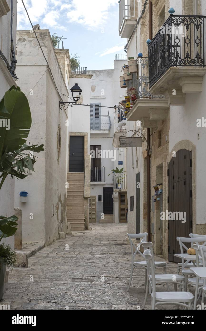Narrow alley in a historic Mediterranean village with white buildings ...