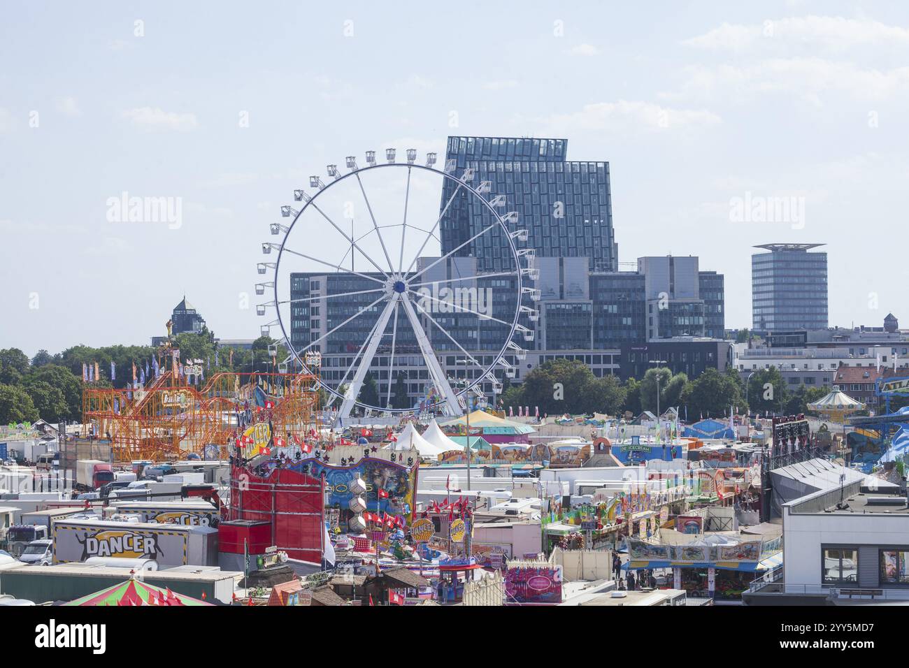 Overview with fairground rides, Ferris wheel and skyscrapers dancing ...