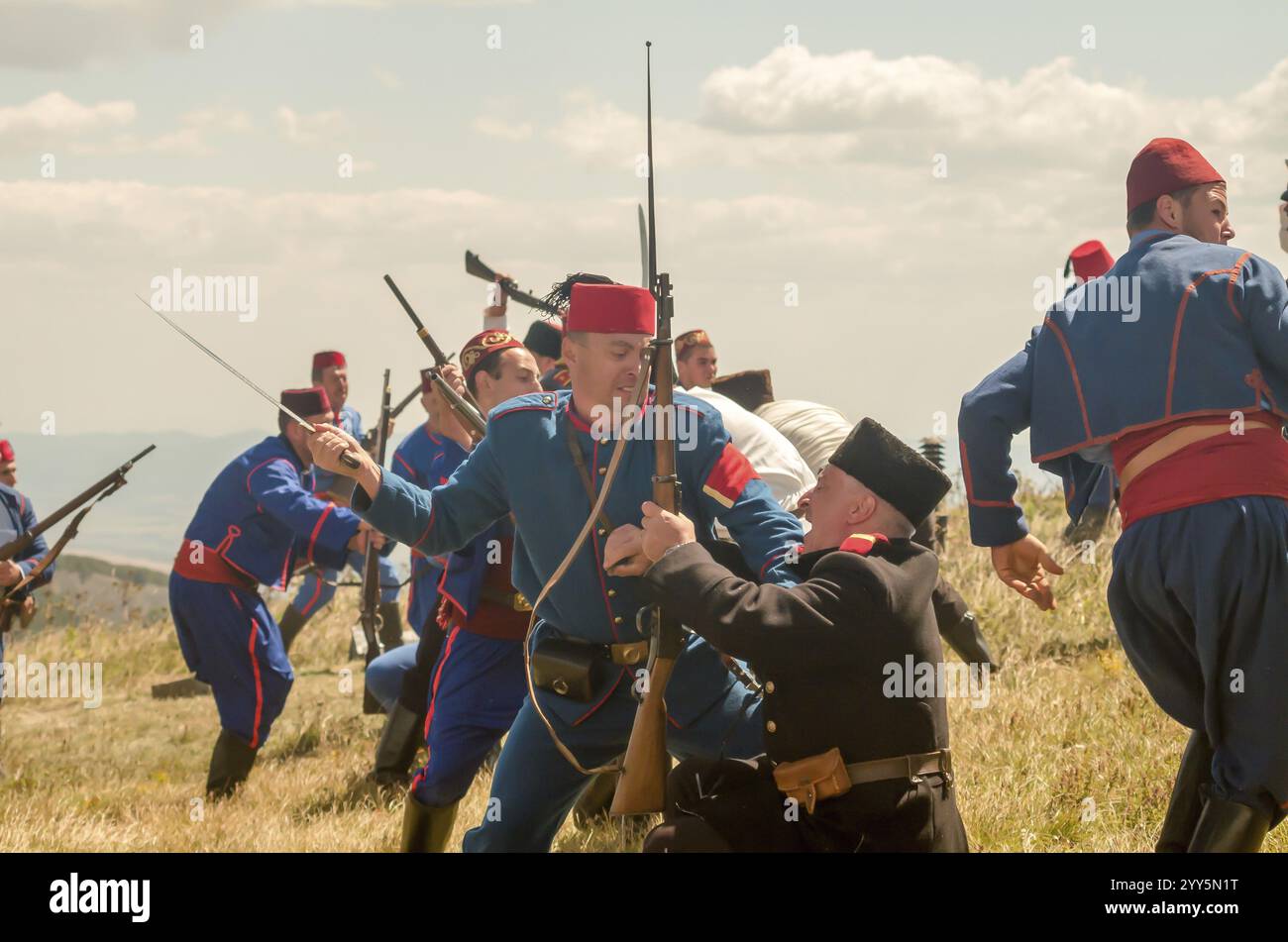 Soldiers in historical uniforms engaging in a battle reenactment on a ...