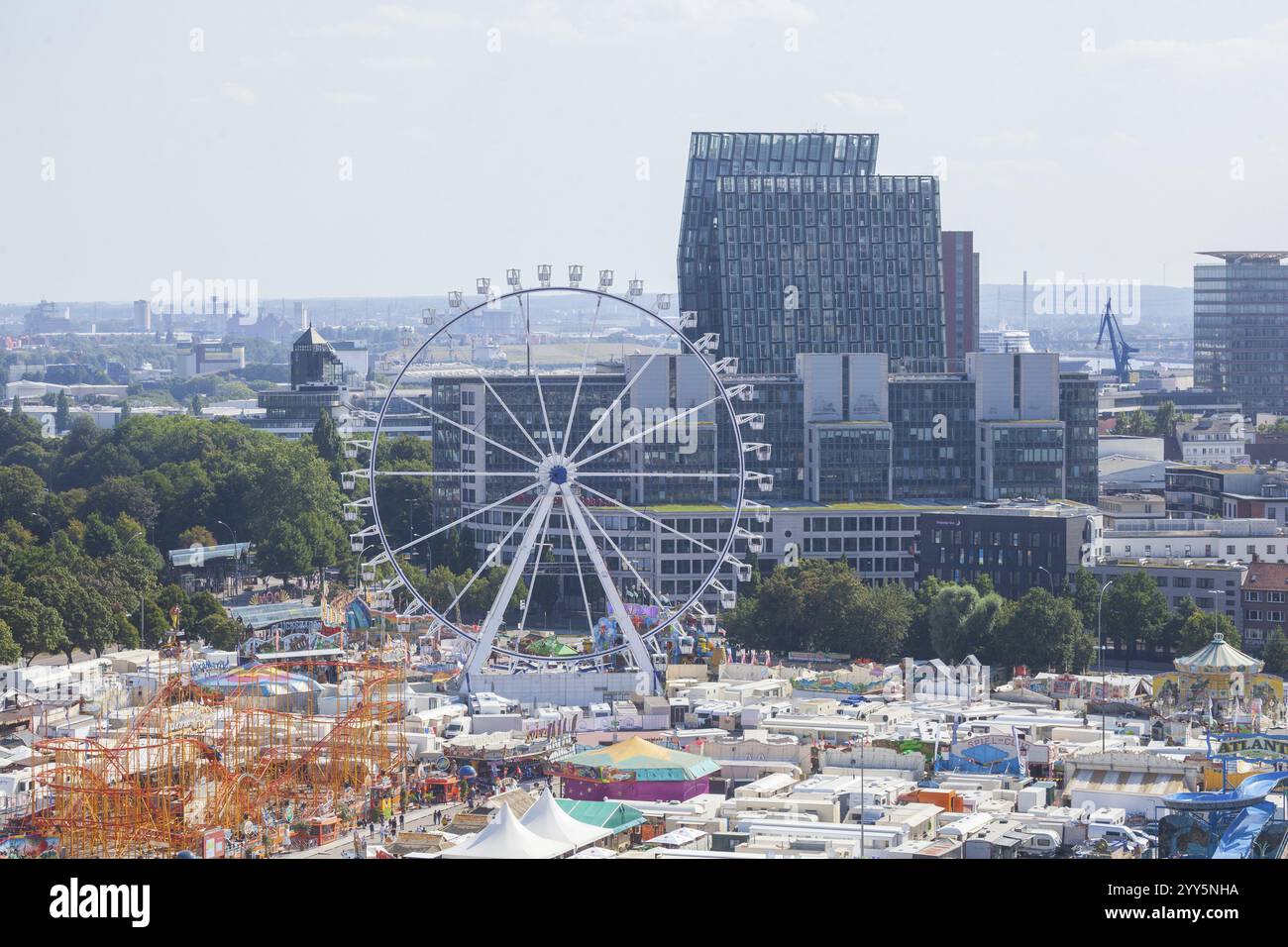 Overview with fairground rides, Ferris wheel and skyscrapers dancing ...