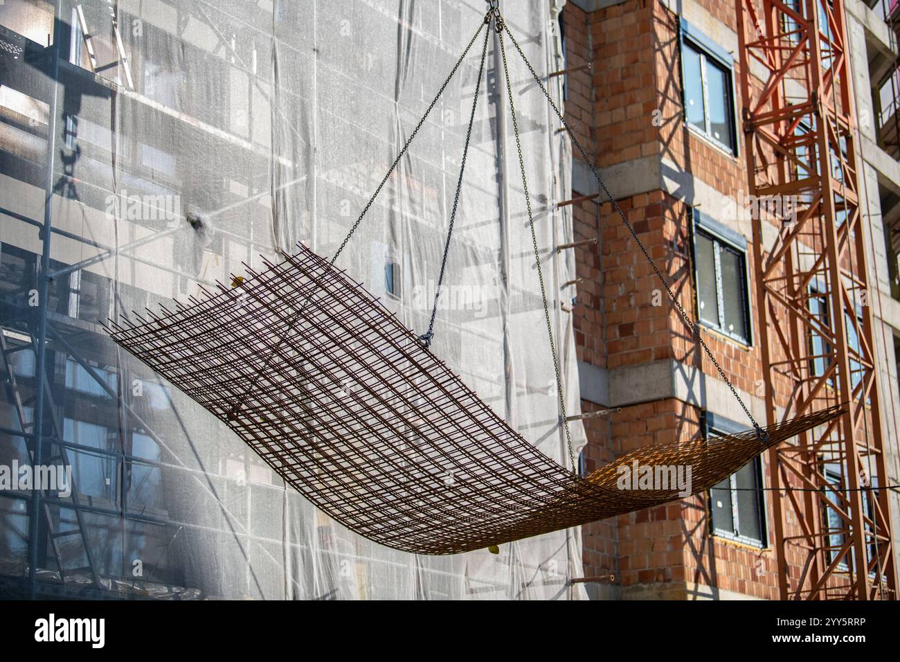 Rebar or armature for concrete pour hanging from the crane in front of ...