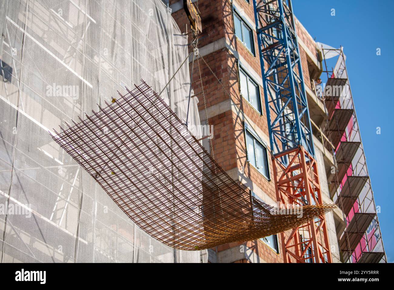 Rebar or armature for concrete pour hanging from the crane in front of ...