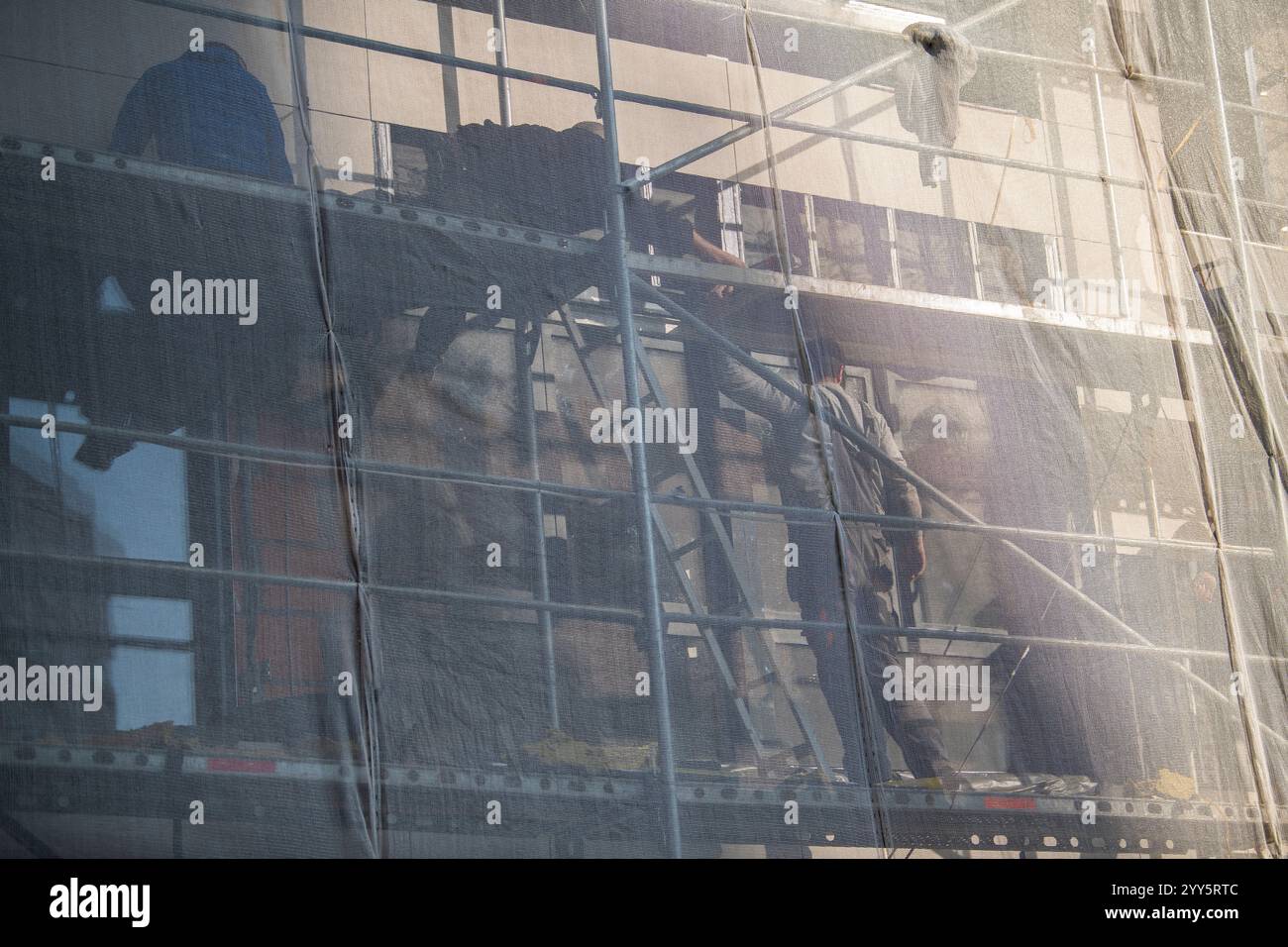 Net wrap or protective mesh covering scaffolding of multi-story ...