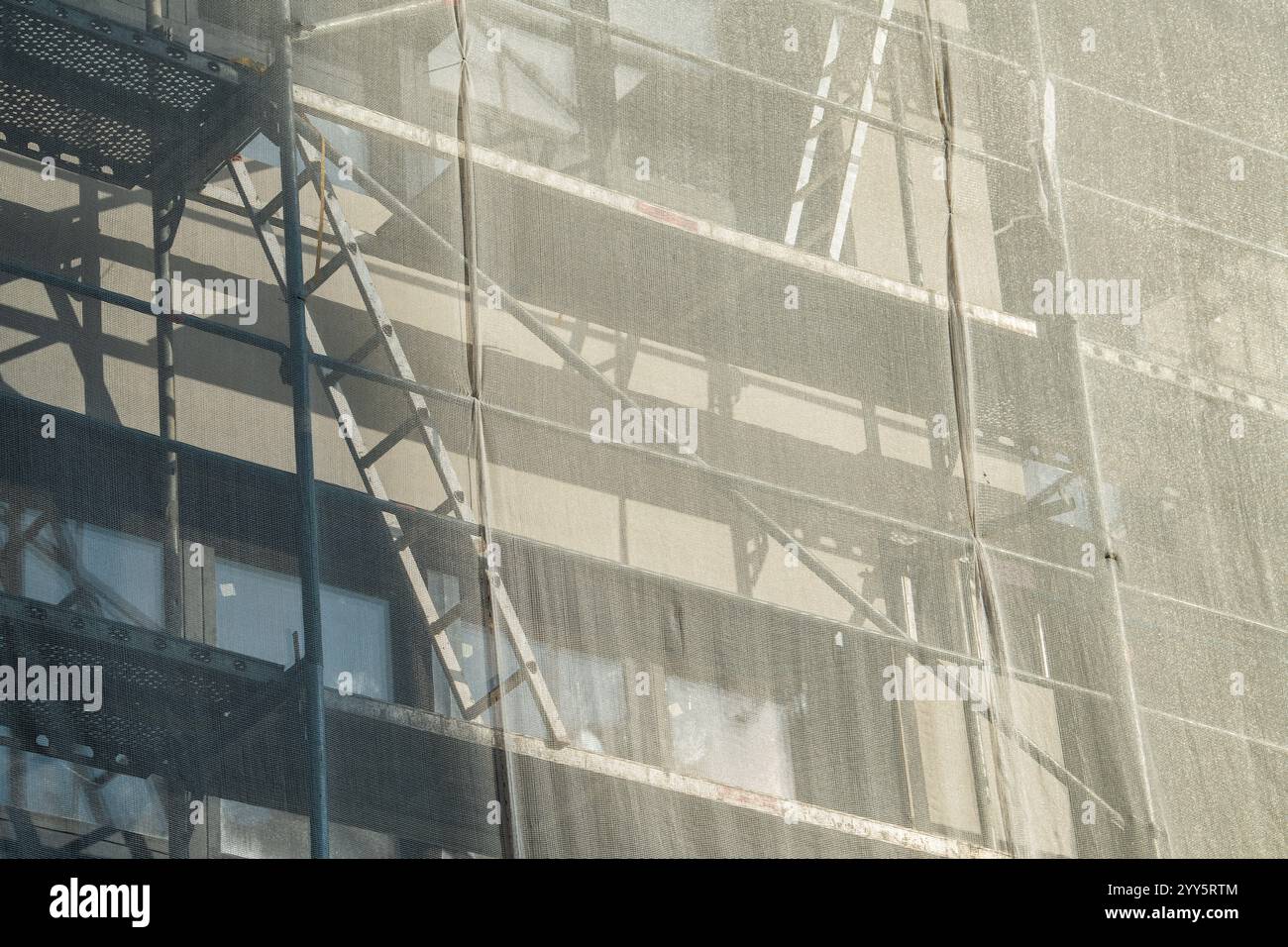 Net wrap or protective mesh covering scaffolding of multi-story ...