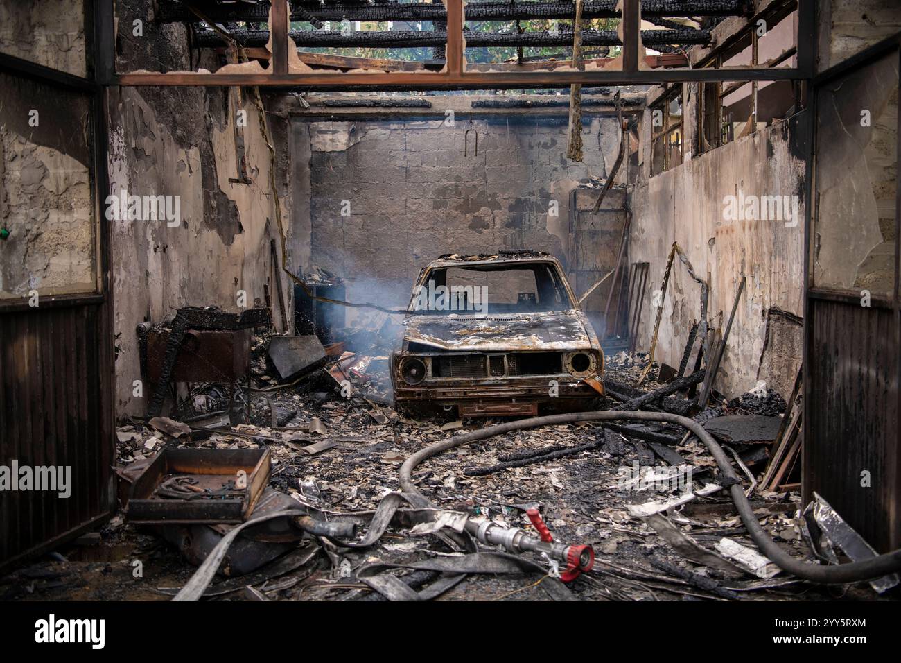 Burned old retro car in a house garage. Explosion and fire disaster in ...