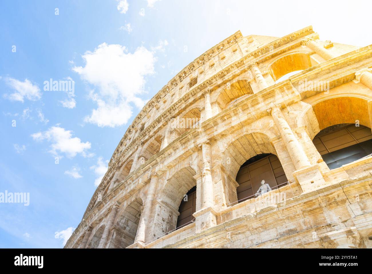 The iconic Colosseum in Rome rises majestically against a clear blue ...