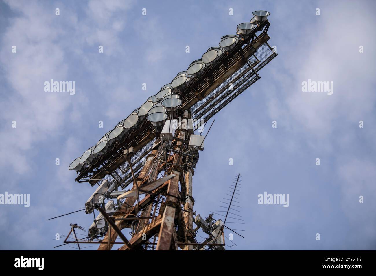 Stadium lights. Old huge spot light lamp system on blue sky background ...