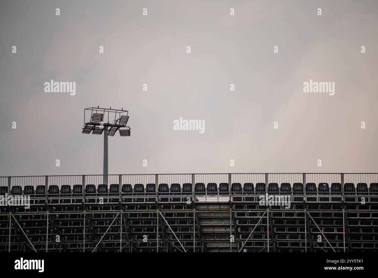 Empty stadium seats from behind. Stadium reflector lights in background ...