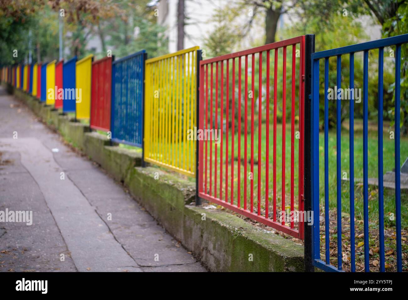Decorative multicolor metal fence at school or kindergarten playground ...
