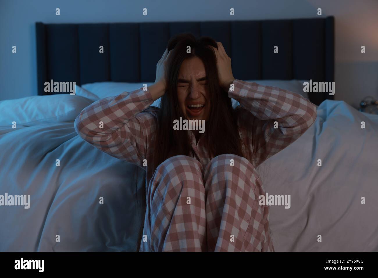 Fear of darkness. Scared young woman in bedroom at night Stock Photo ...