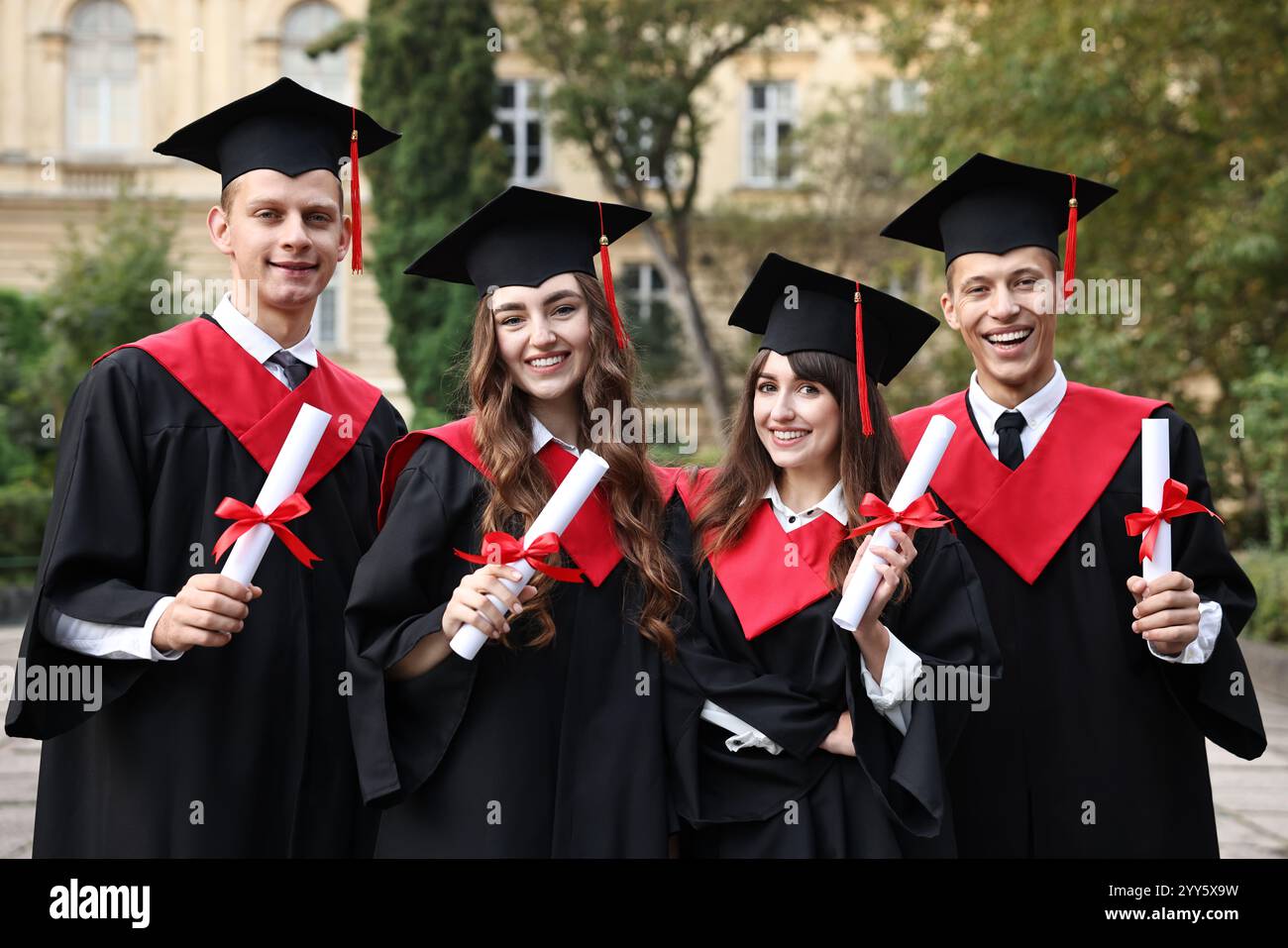 Happy students with diplomas after graduation ceremony outdoors Stock ...