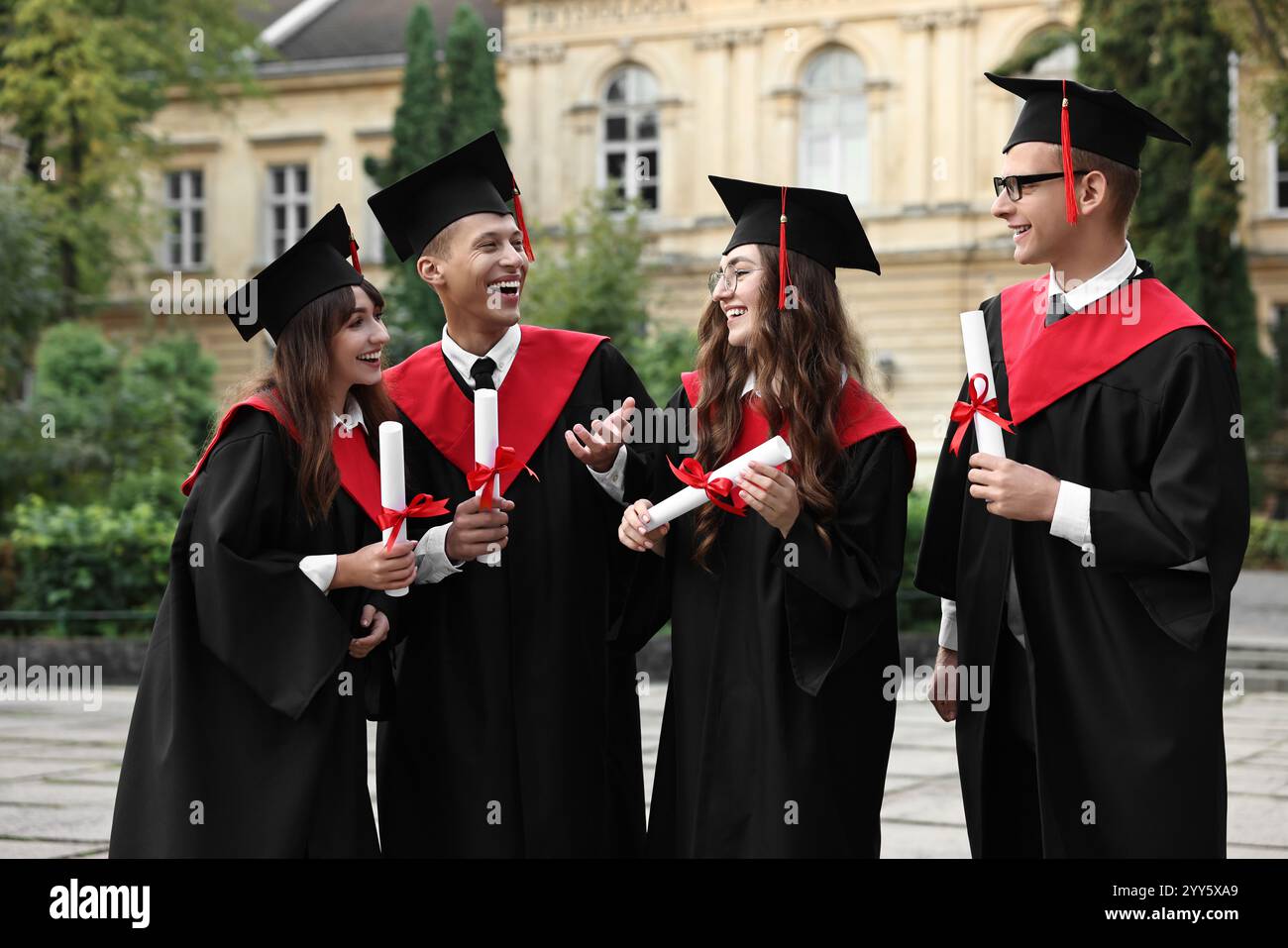 Happy students with diplomas after graduation ceremony outdoors Stock ...
