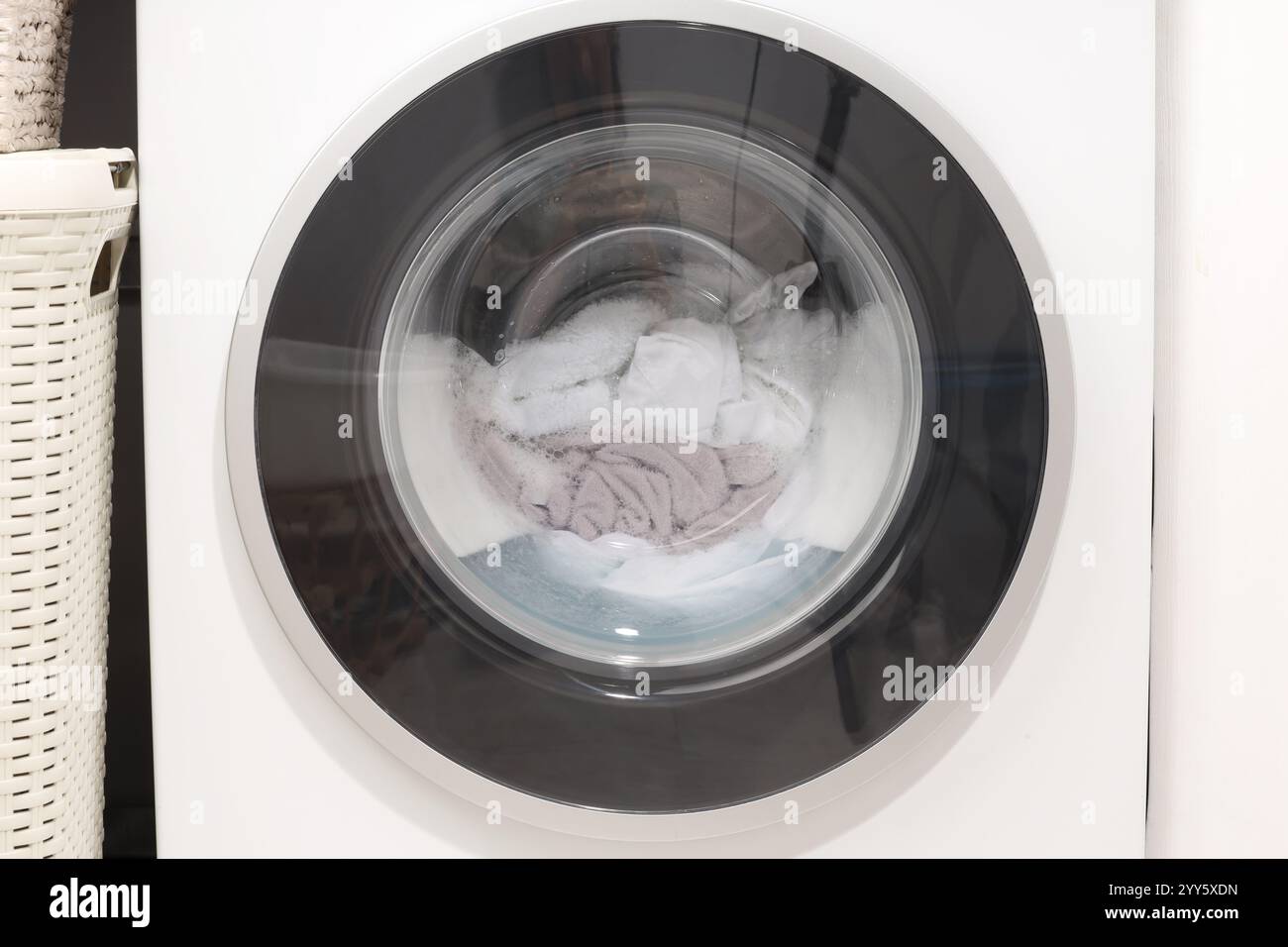 Washing machine with clothes as background, closeup Stock Photo - Alamy