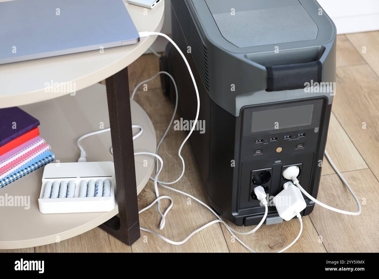 Modern portable power station, charging attached devices indoors Stock ...