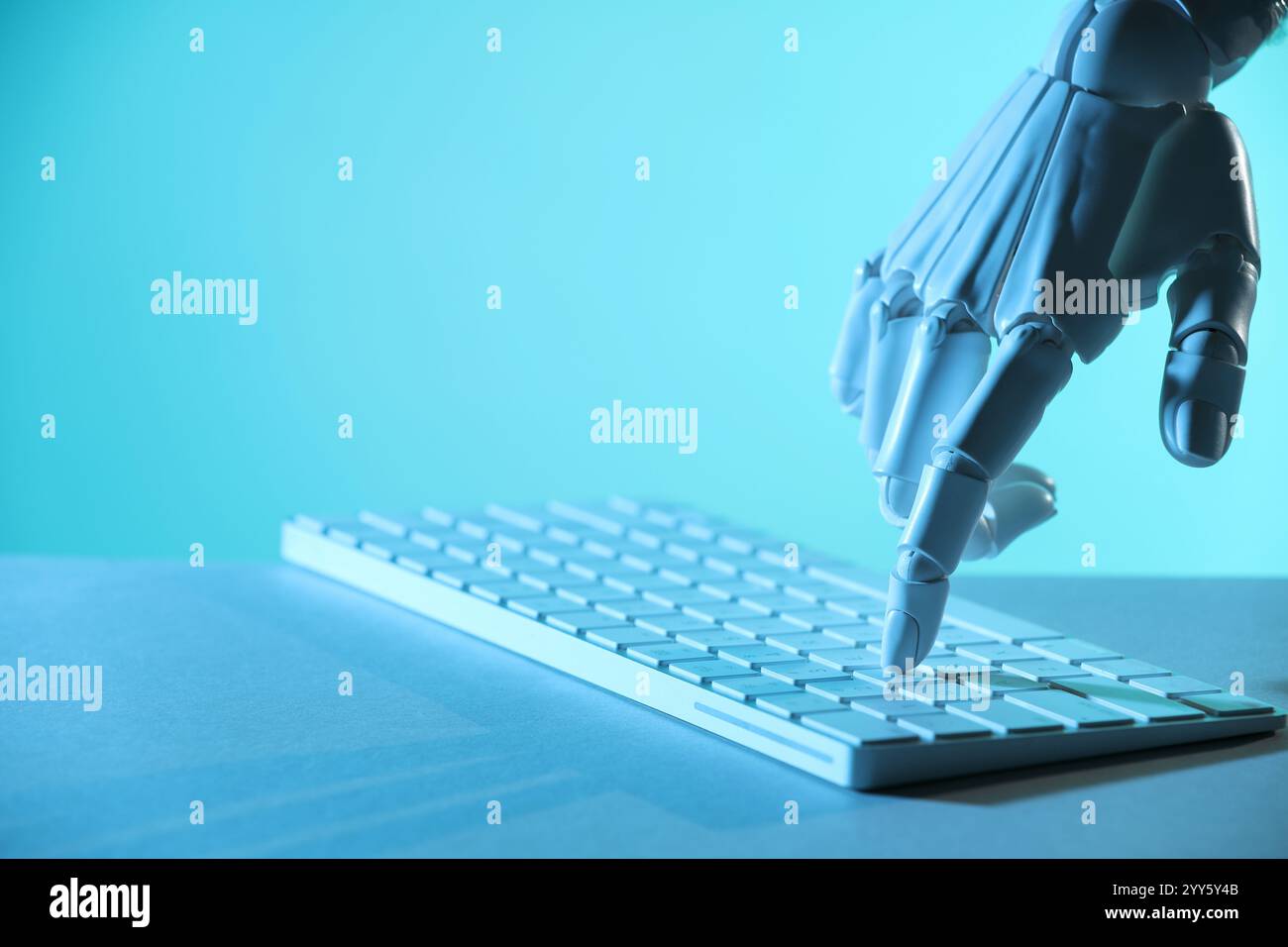 Artificial intelligence. Robot hand using keyboard at table in blue ...