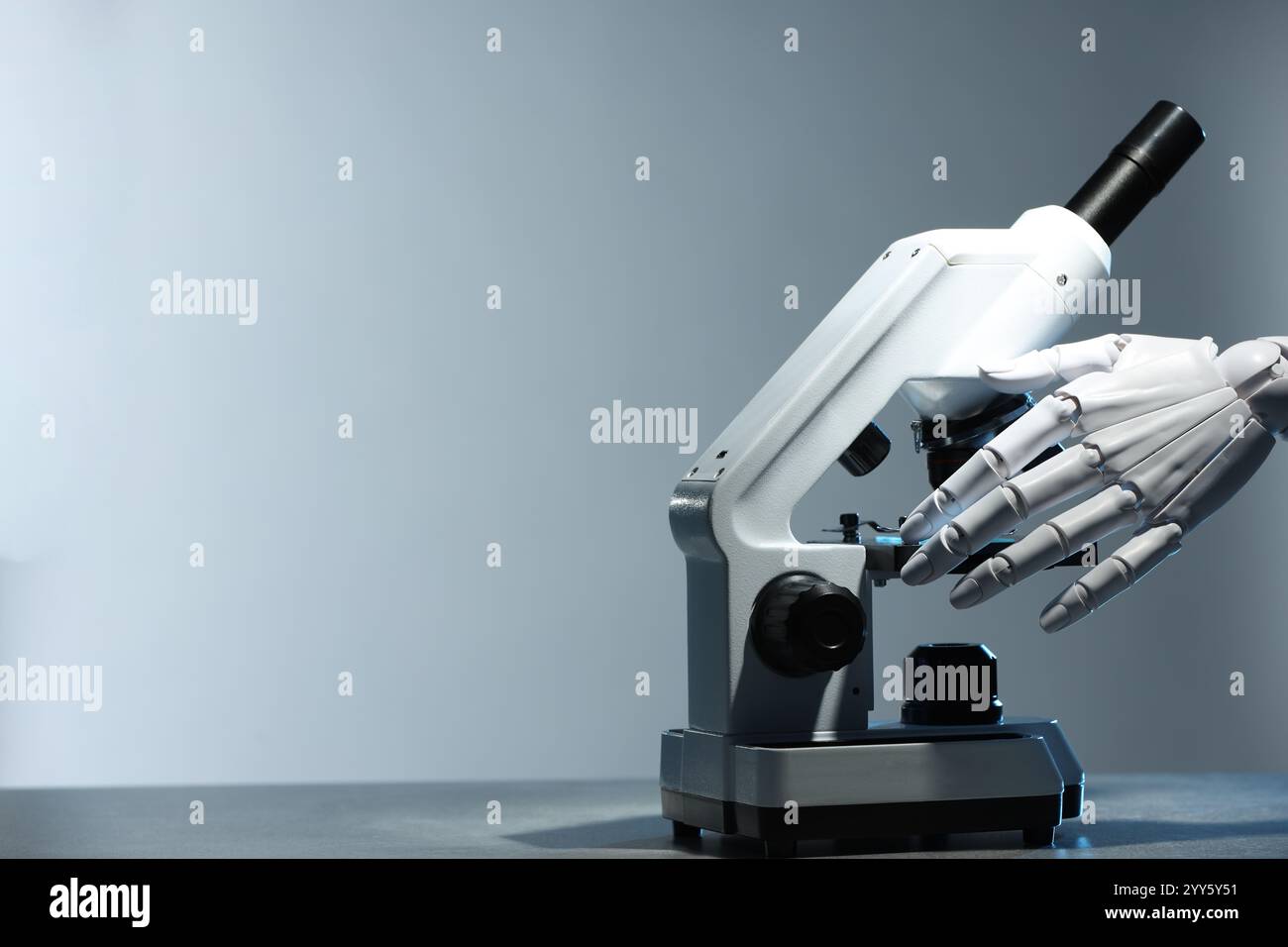Artificial intelligence. Robot hand working with microscope at table ...
