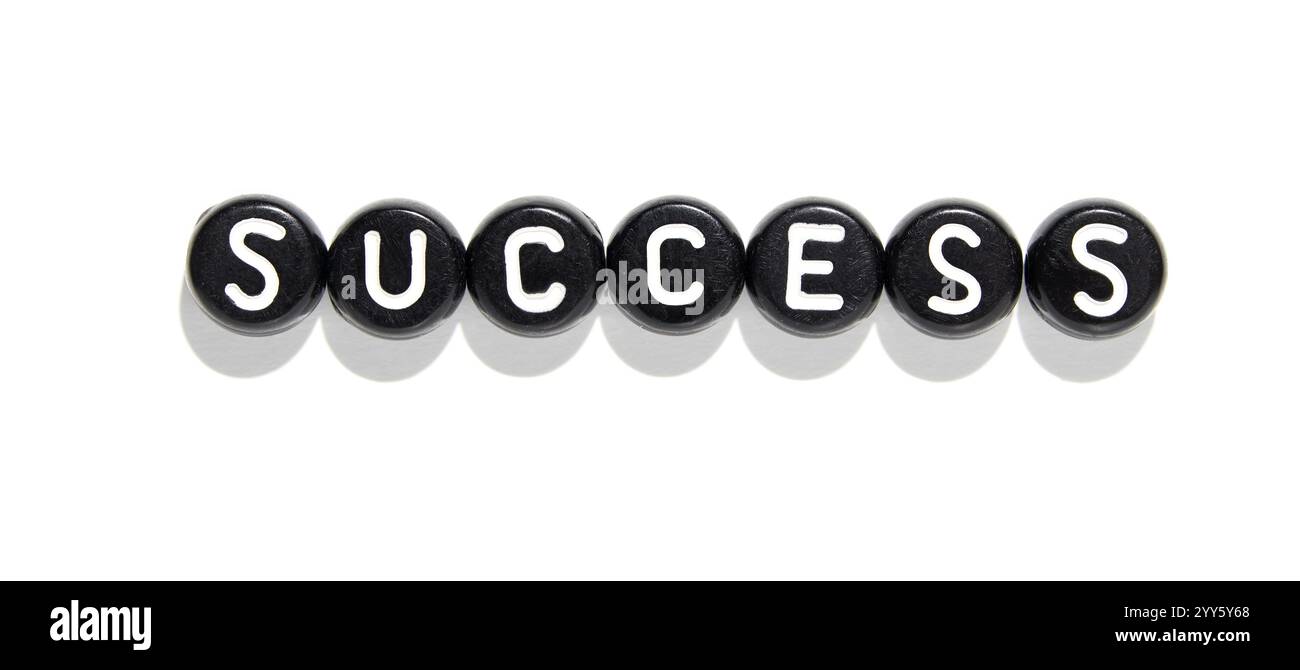 Minimalist alphabet beads arranged to spell success on white background ...