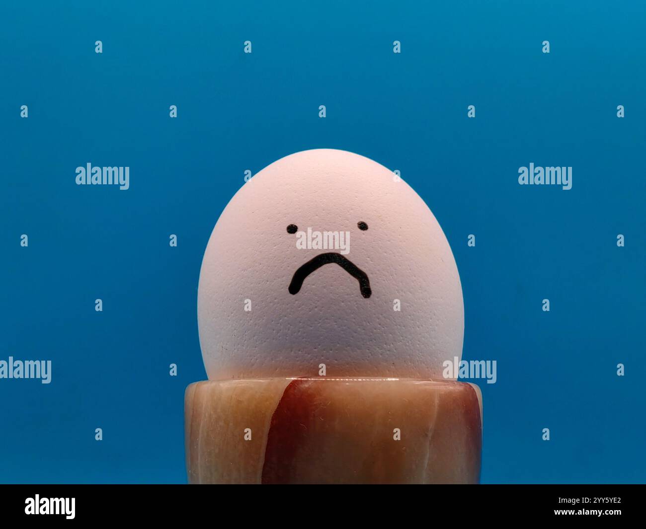 Sad White Egg, in brown marble mini cup. Emotions on blue Canvas ...