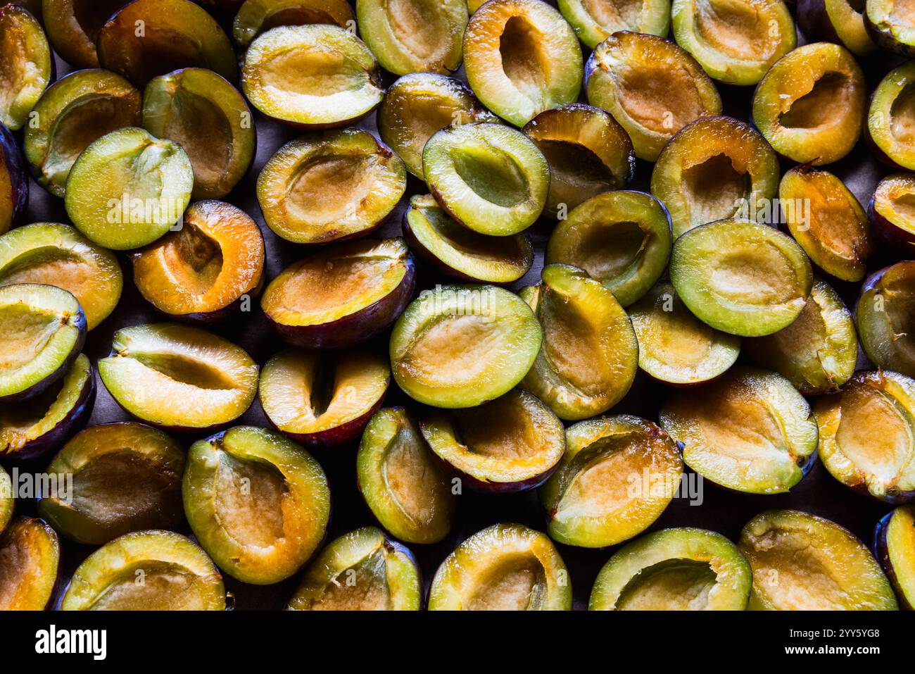 A close-up of Hungarian plums cut in half, ready for drying Stock Photo ...
