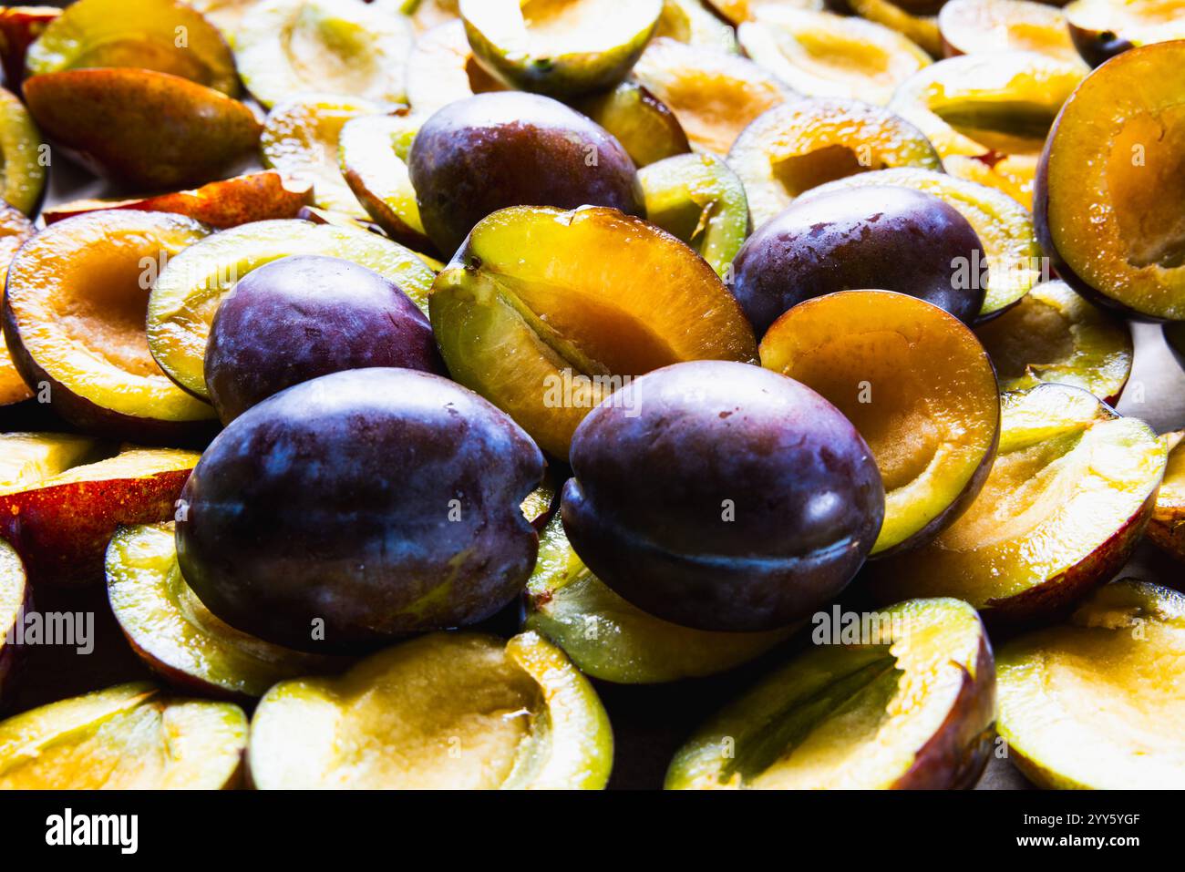 A close-up of Hungarian plums cut in half, ready for drying Stock Photo ...