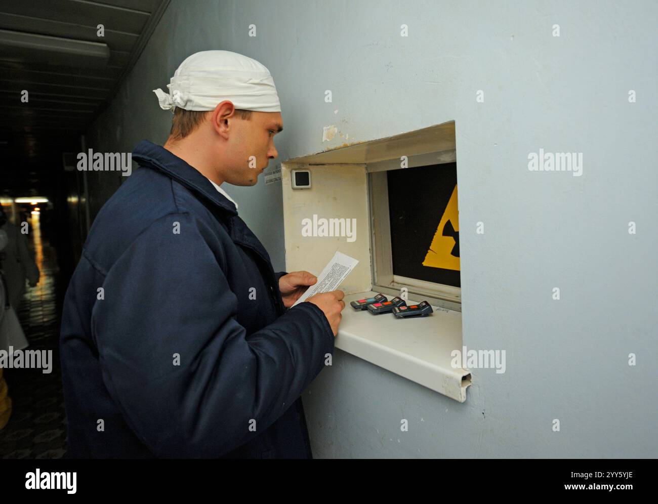 Technician standing in front of window of the radiation control post ...
