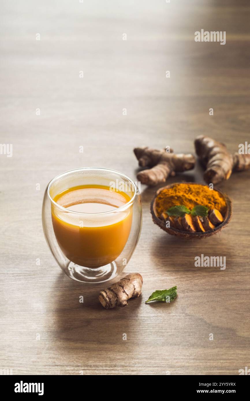 Organic orange turmeric drink, tea with cinnamon in a glass mug with ...