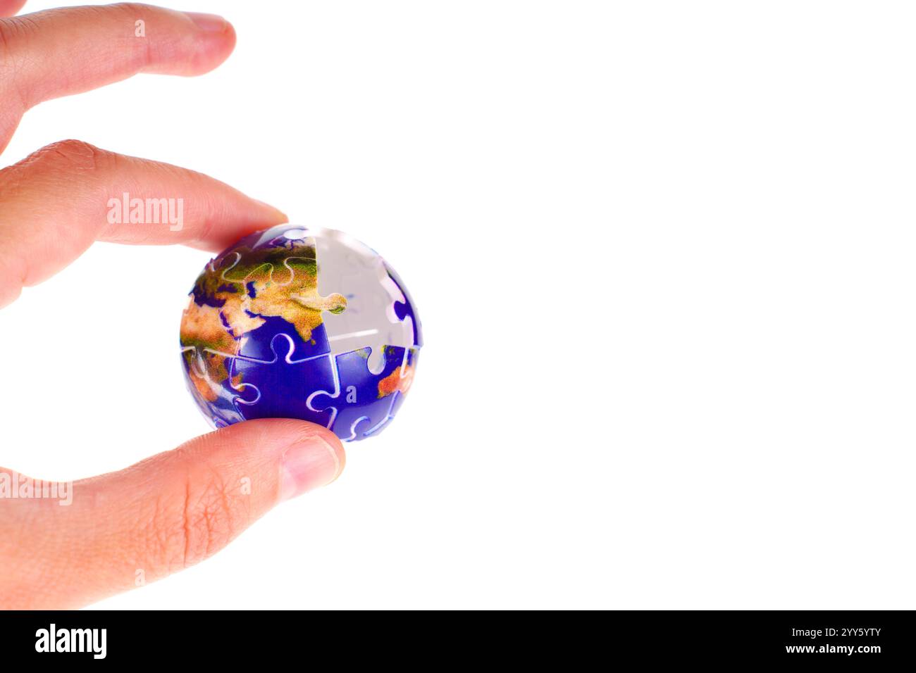 Hand grasping a colorful globe puzzle, illustrating the beauty of Earth ...