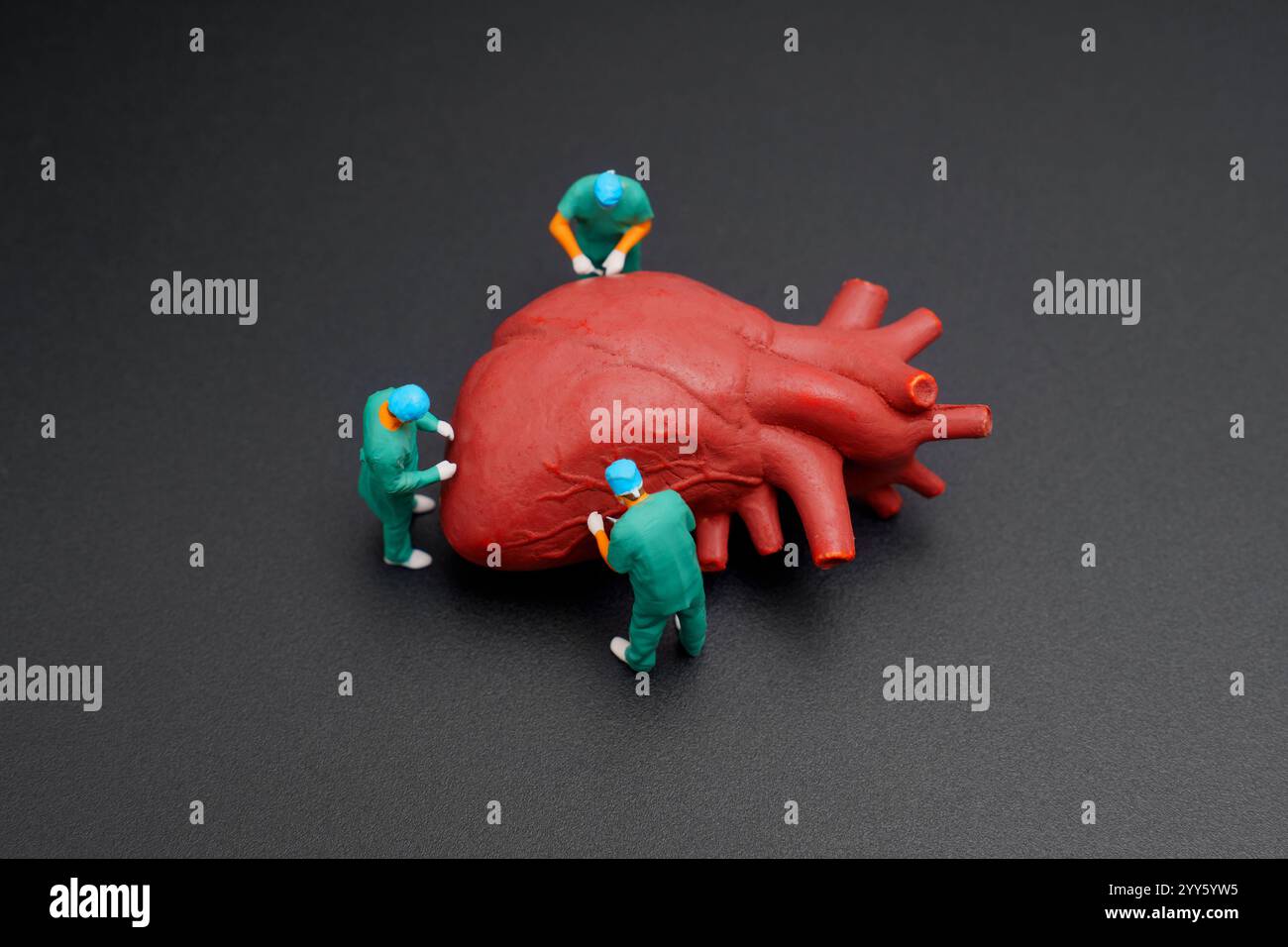 Miniature surgeons check-up a realistic model of a human heart ...